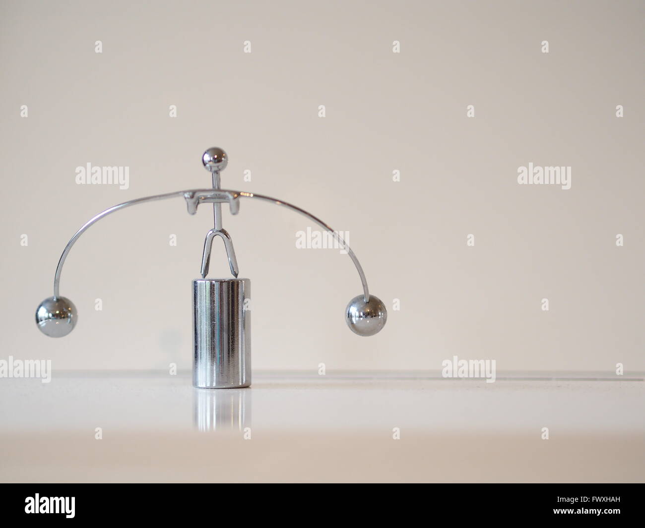 Silver figure holding weights and keeping balance Stock Photo - Alamy