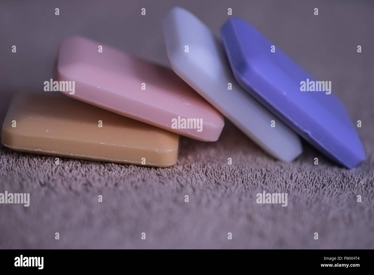 four multi-colored bars of soap on a towel Stock Photo - Alamy