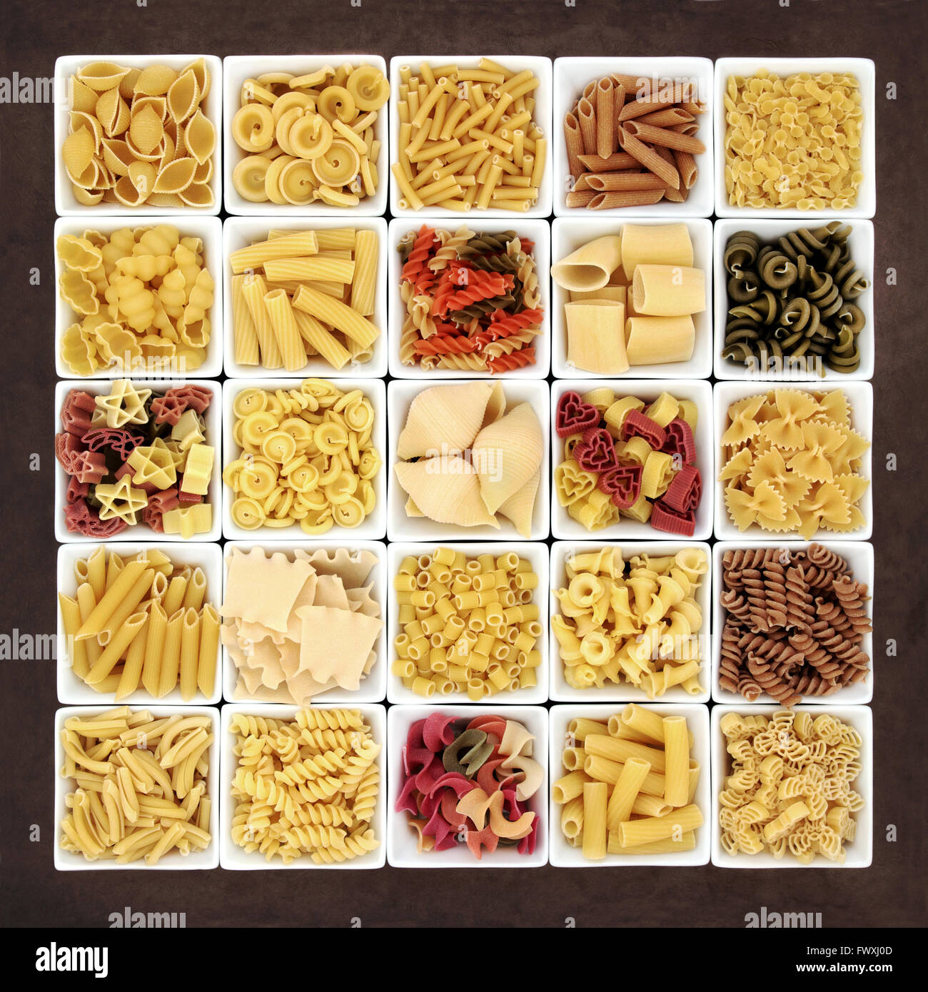 Large pasta dried food sampler in square dishes over brown lokta paper ...