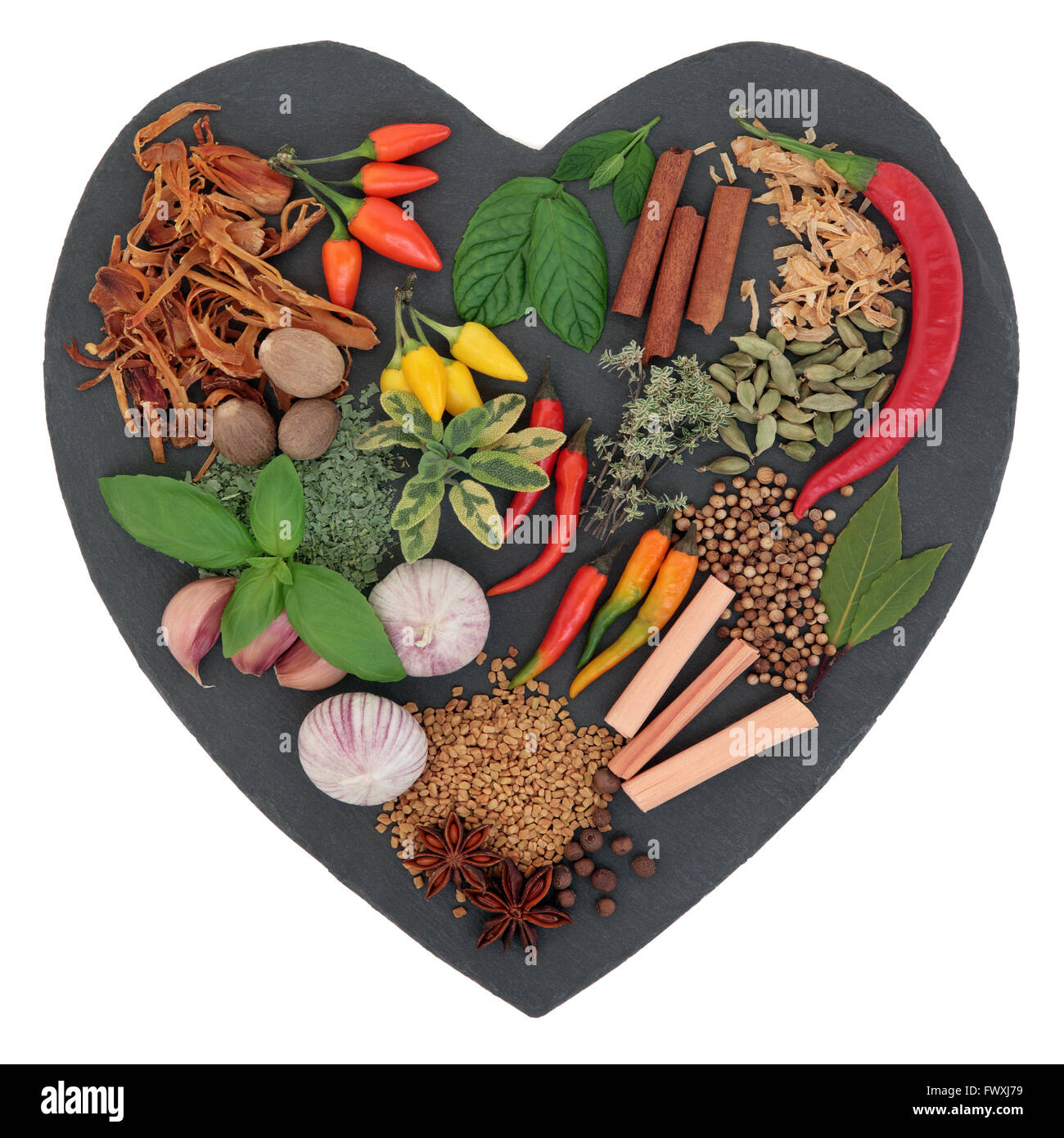Herb and spice selection on heart shaped slate over white background ...