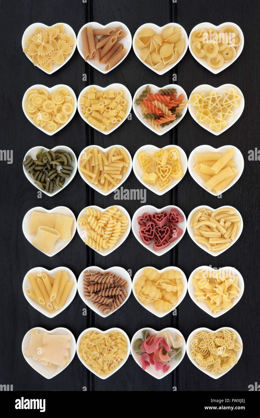 Large pasta food selection in heart shaped porcelain dishes over dark ...