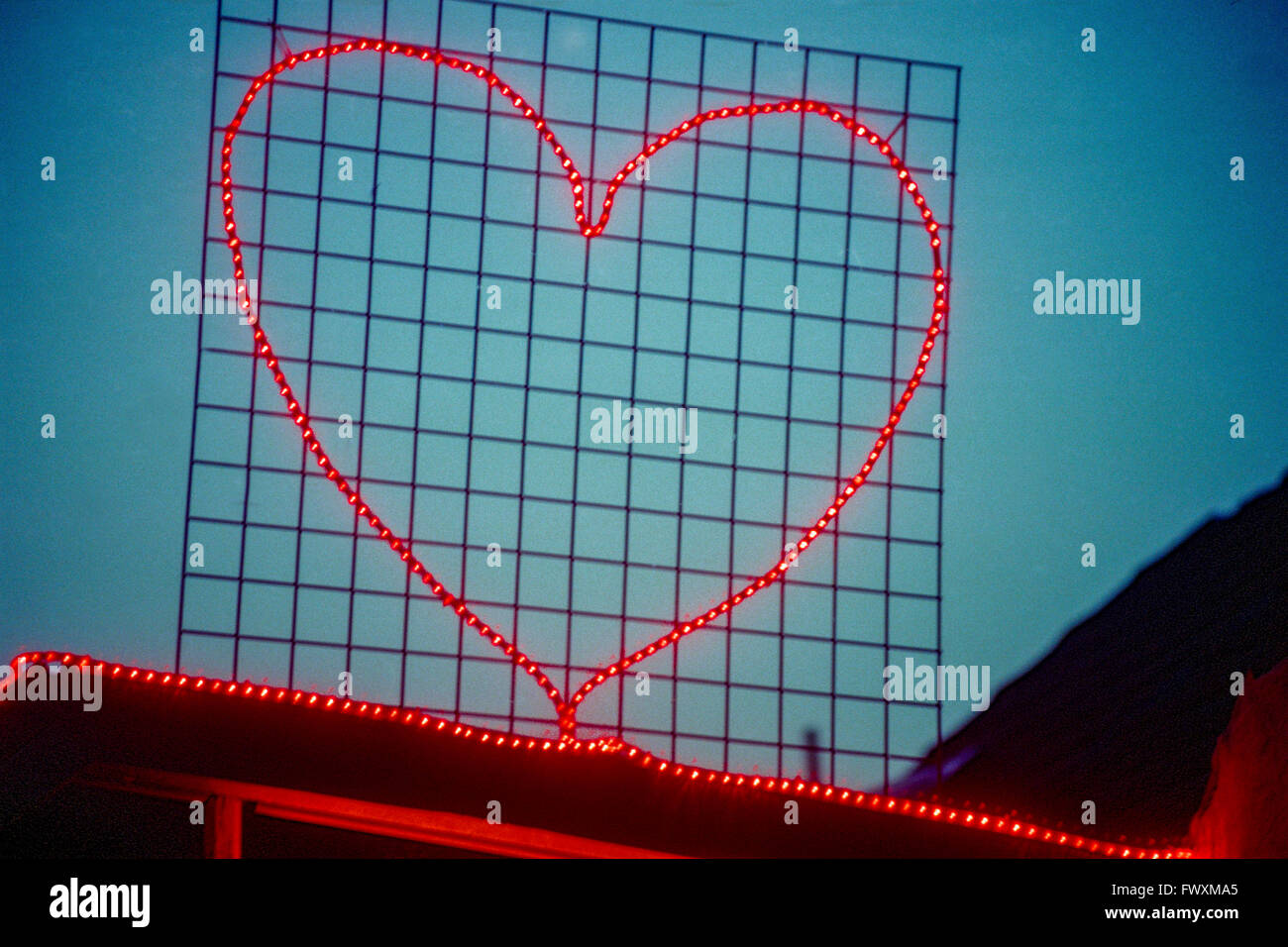 Light shaped to love heart-shaped symbol on the roof of the house Stock ...