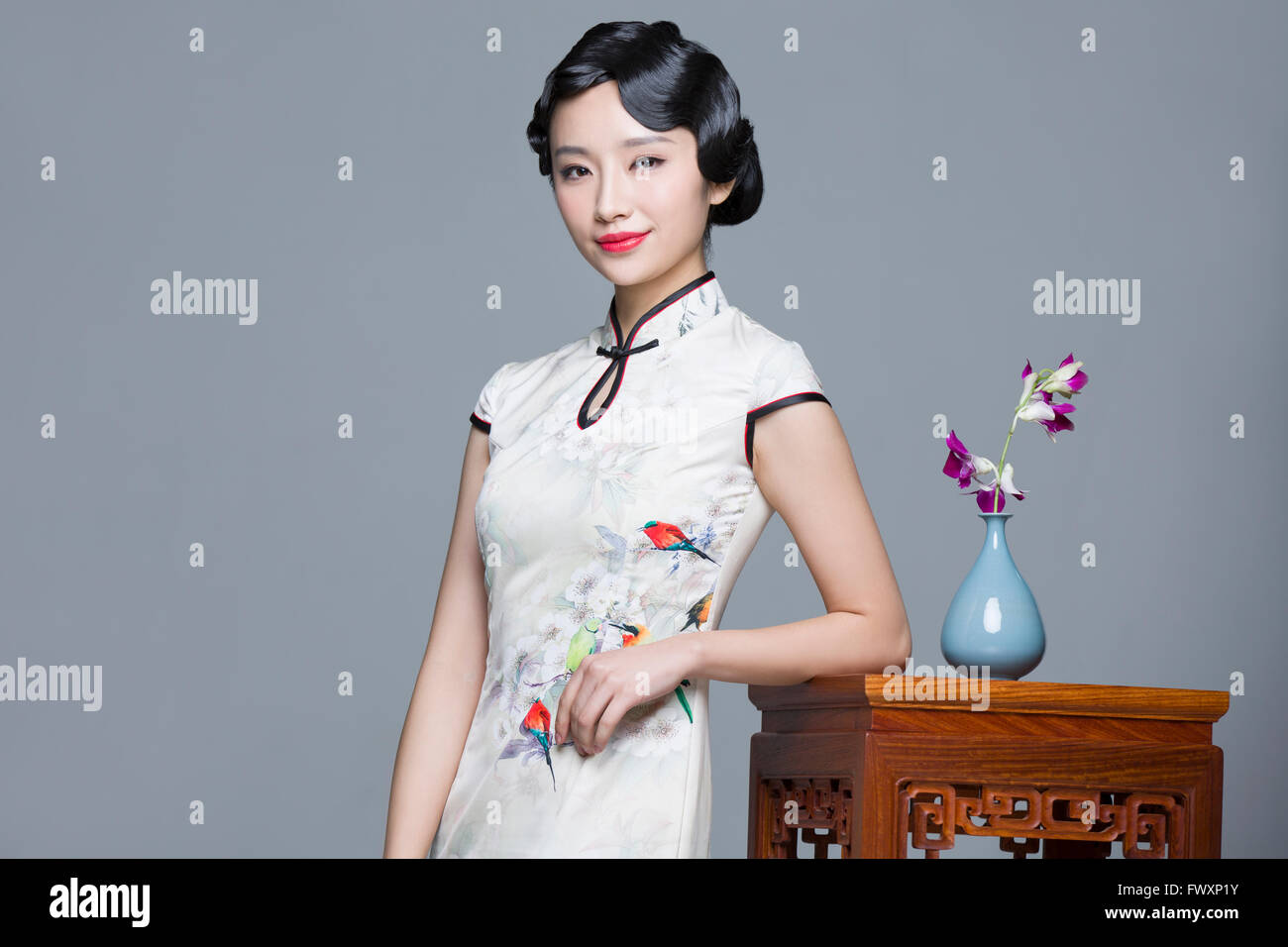 Young beautiful woman in traditional cheongsam with orchid Stock Photo ...