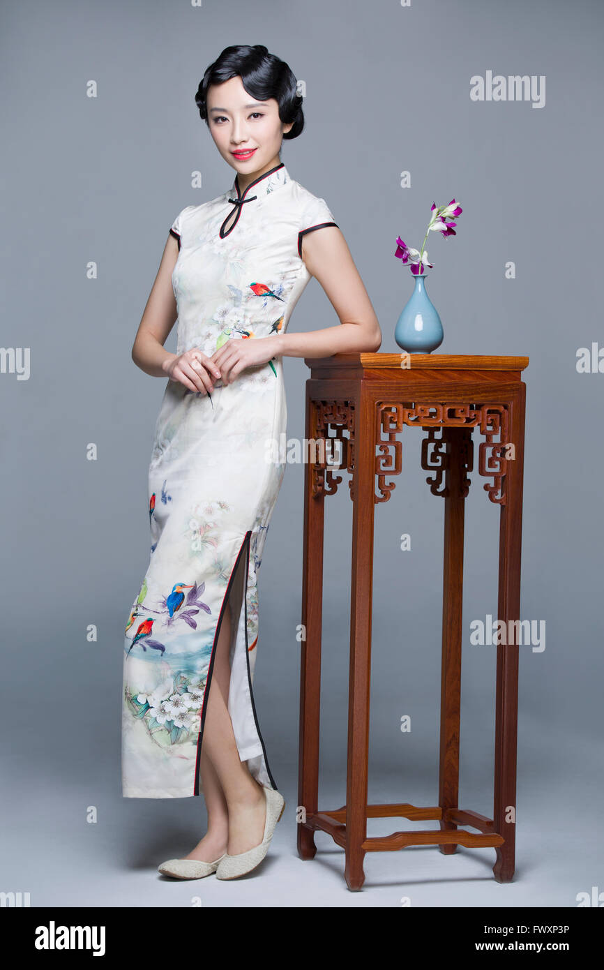 Young beautiful woman in traditional cheongsam with orchid Stock Photo ...