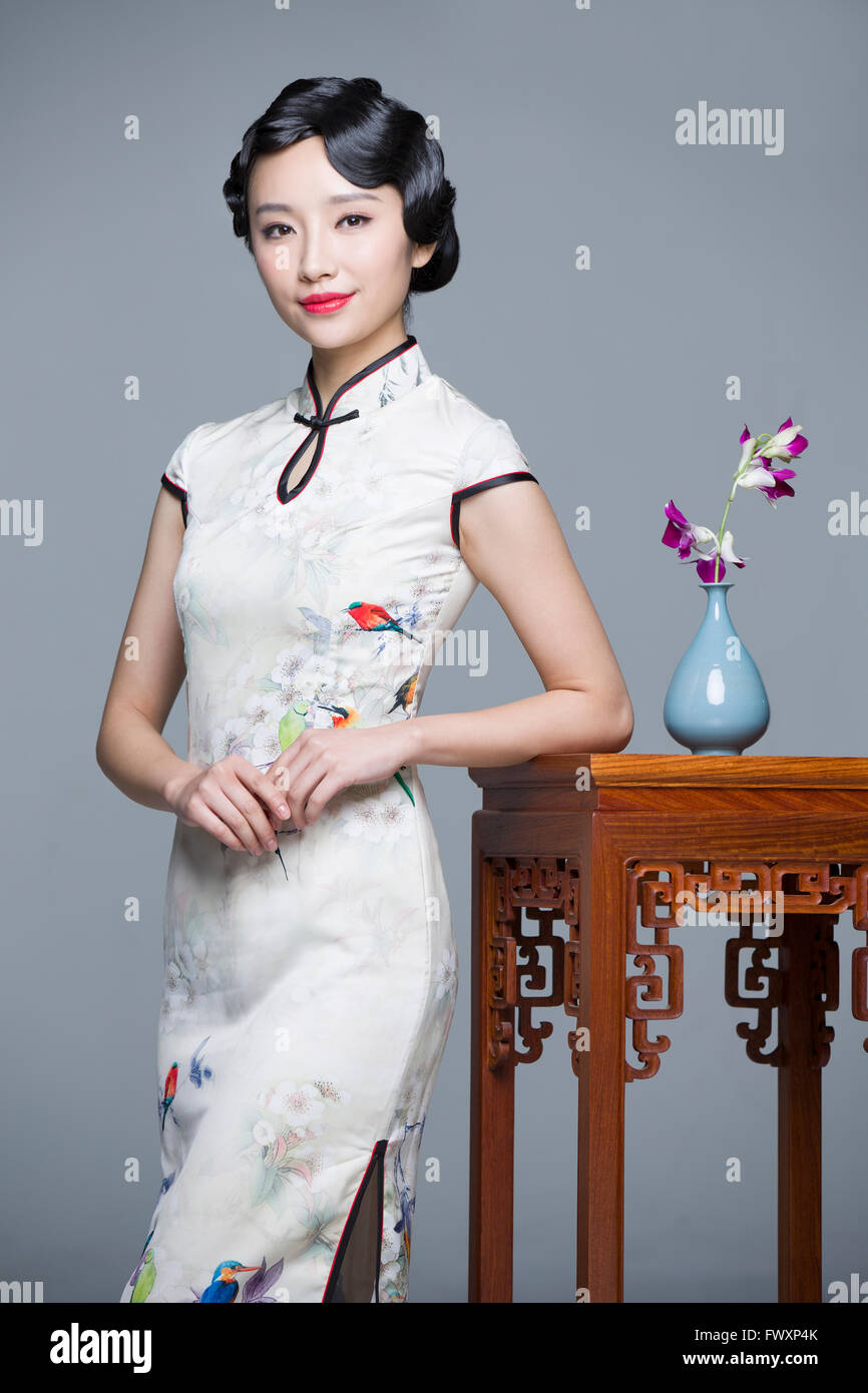 Young beautiful woman in traditional cheongsam with orchid Stock Photo ...