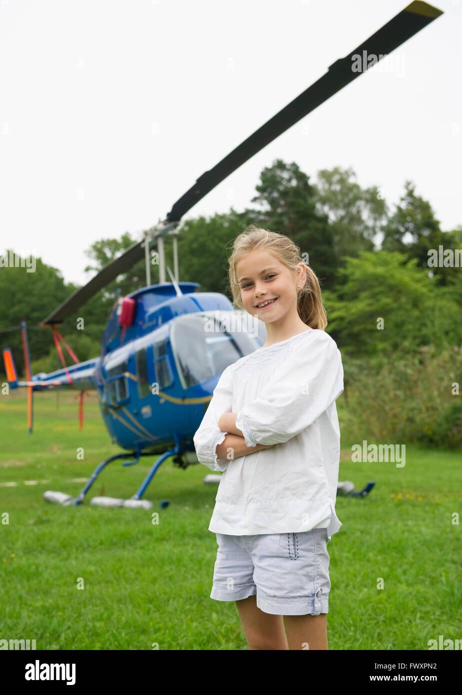 Sweden, Stockholm, Portrait of girl (8-9) with helicopter in background ...