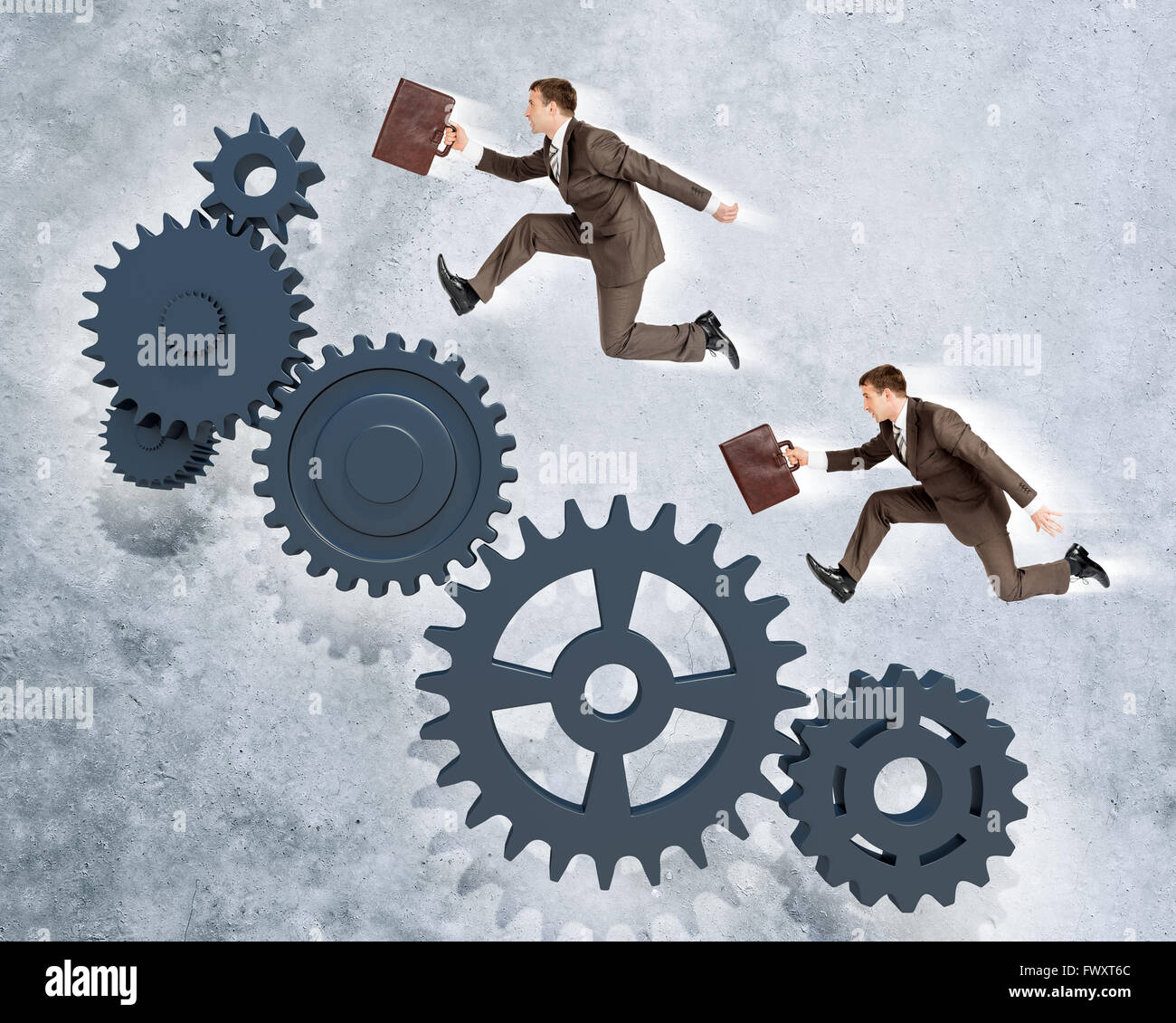 Two businessmen running on wheel gears Stock Photo - Alamy