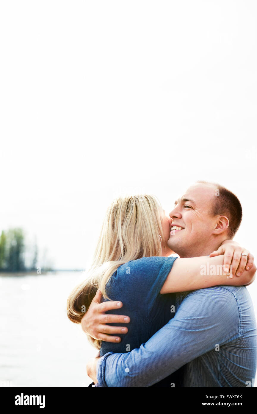 Sweden, Gastrikland, Sandviken, Smiling couple hugging with lake in ...