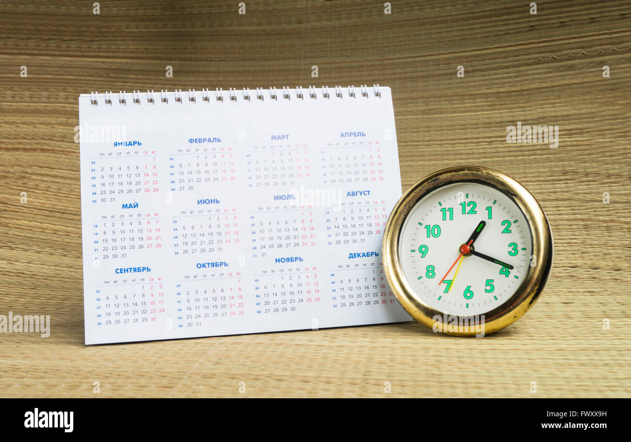 Round watch with desk paper calendar on beige background Stock Photo ...