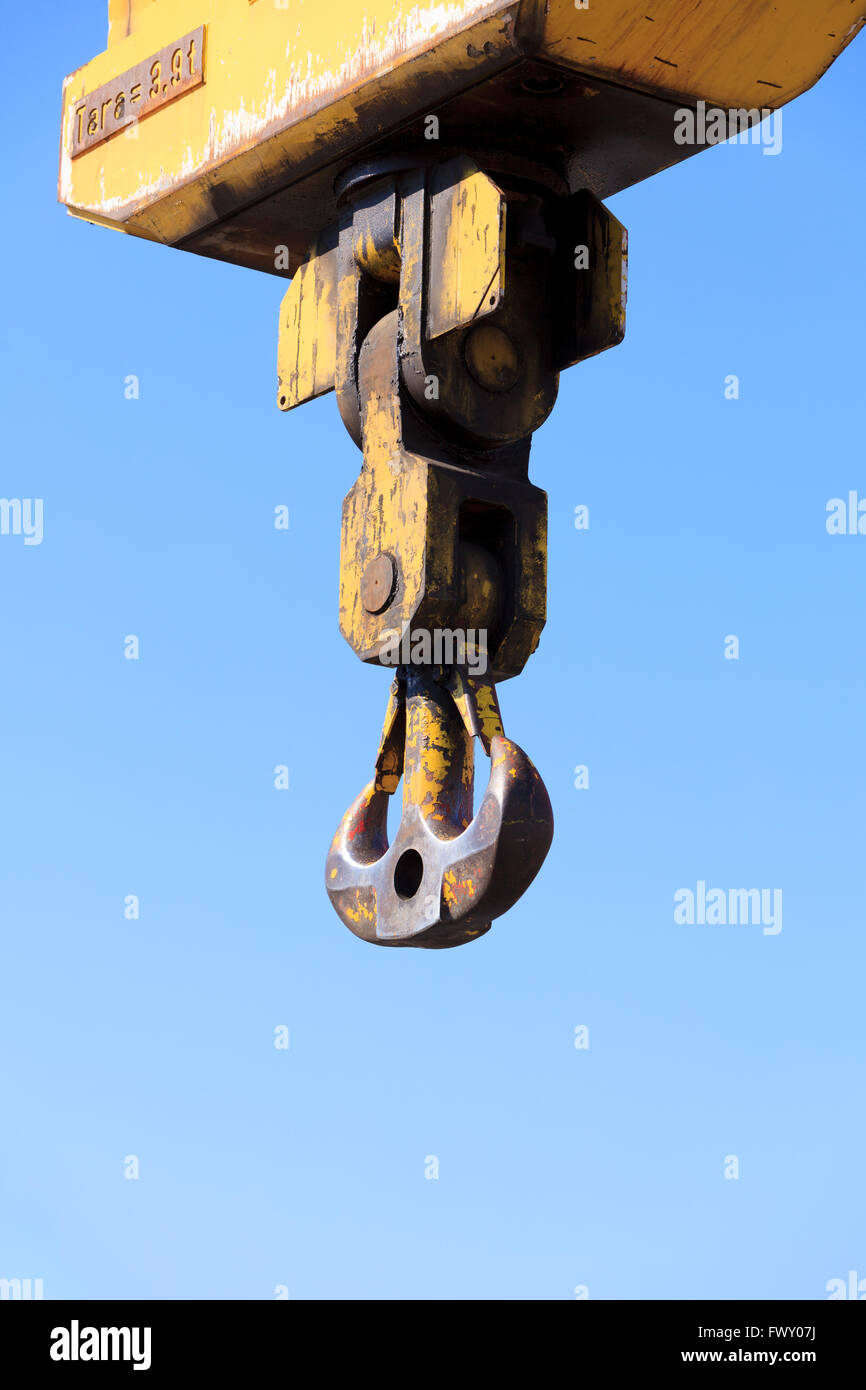 Business and commerce. Closeup crane hook at port area and blue sky ...