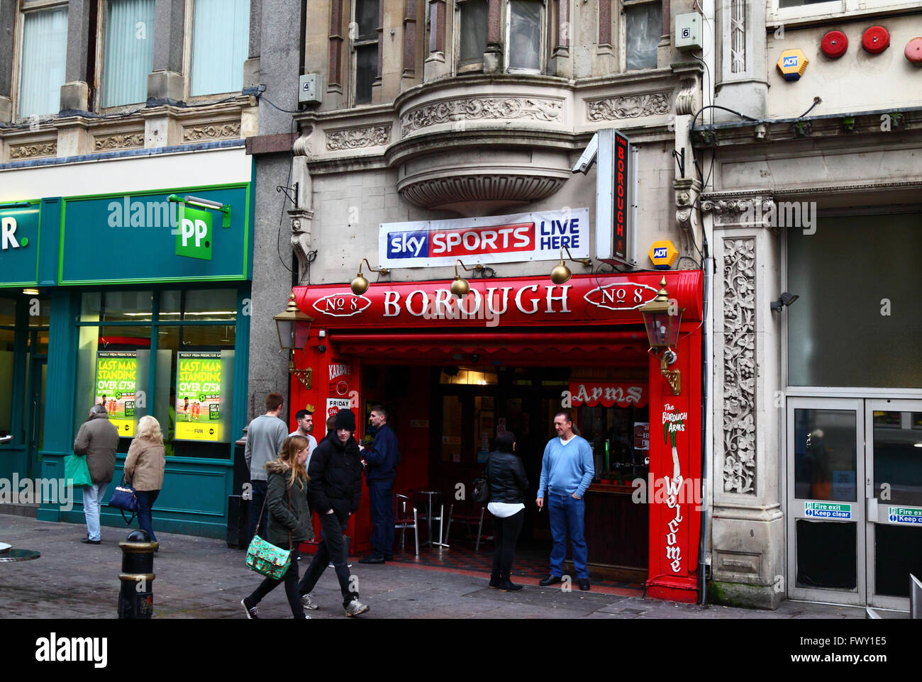 People chatting and smoking outside entrance to The Borough Arms pub at ...