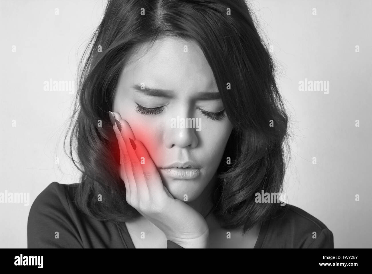 Teen woman pressing her bruised cheek with a painful expression as if ...