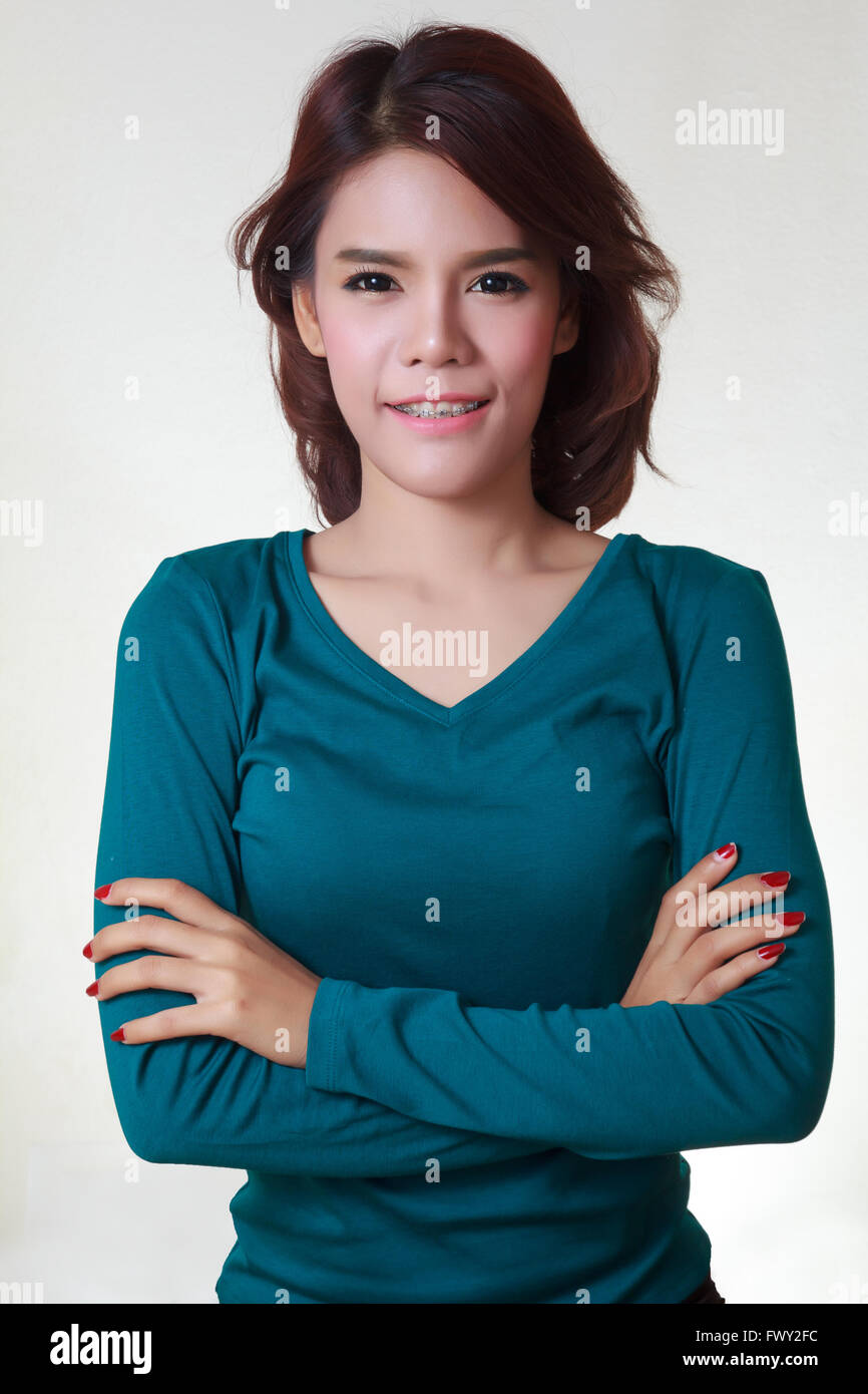 Young woman crossed arms standing against white. Confident pose Stock ...