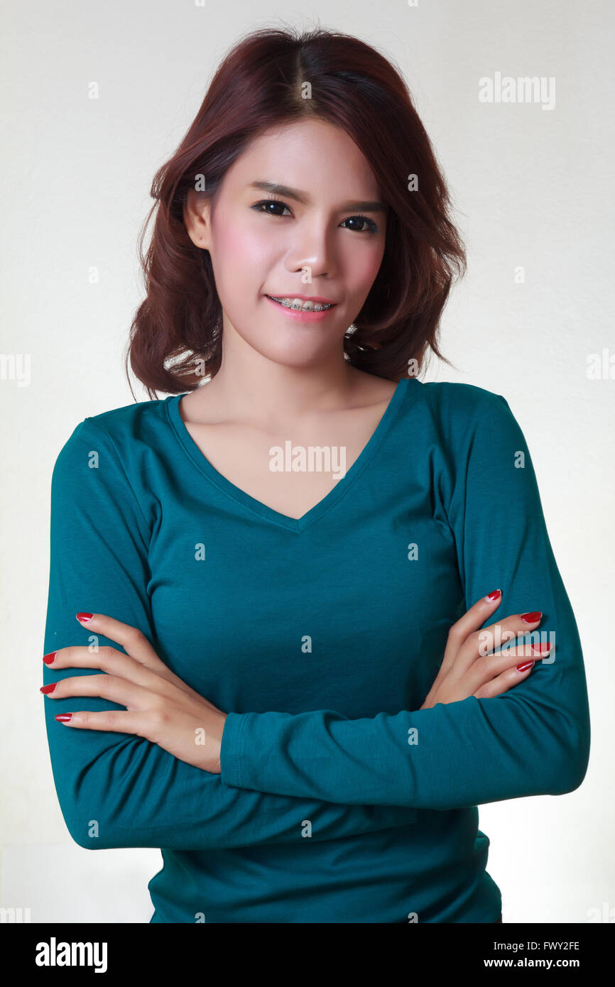 Young woman crossed arms standing against white. Confident pose Stock ...