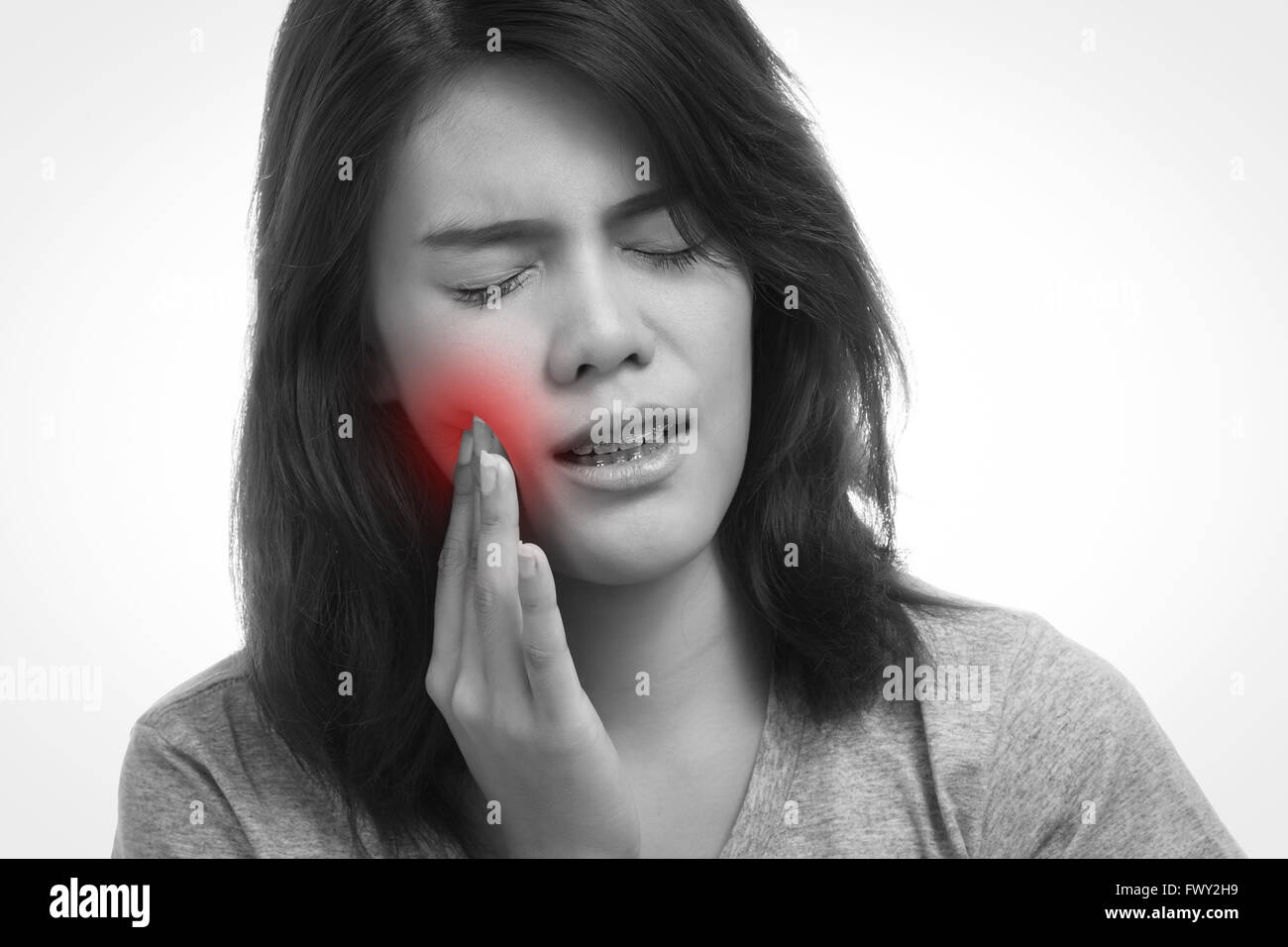 Teen woman pressing her bruised cheek with a painful expression as if ...