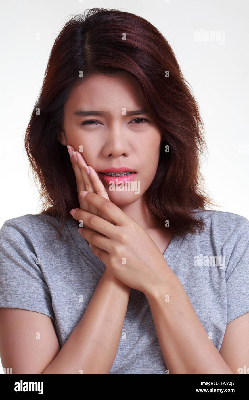 Teen woman pressing her bruised cheek with a painful expression as if ...