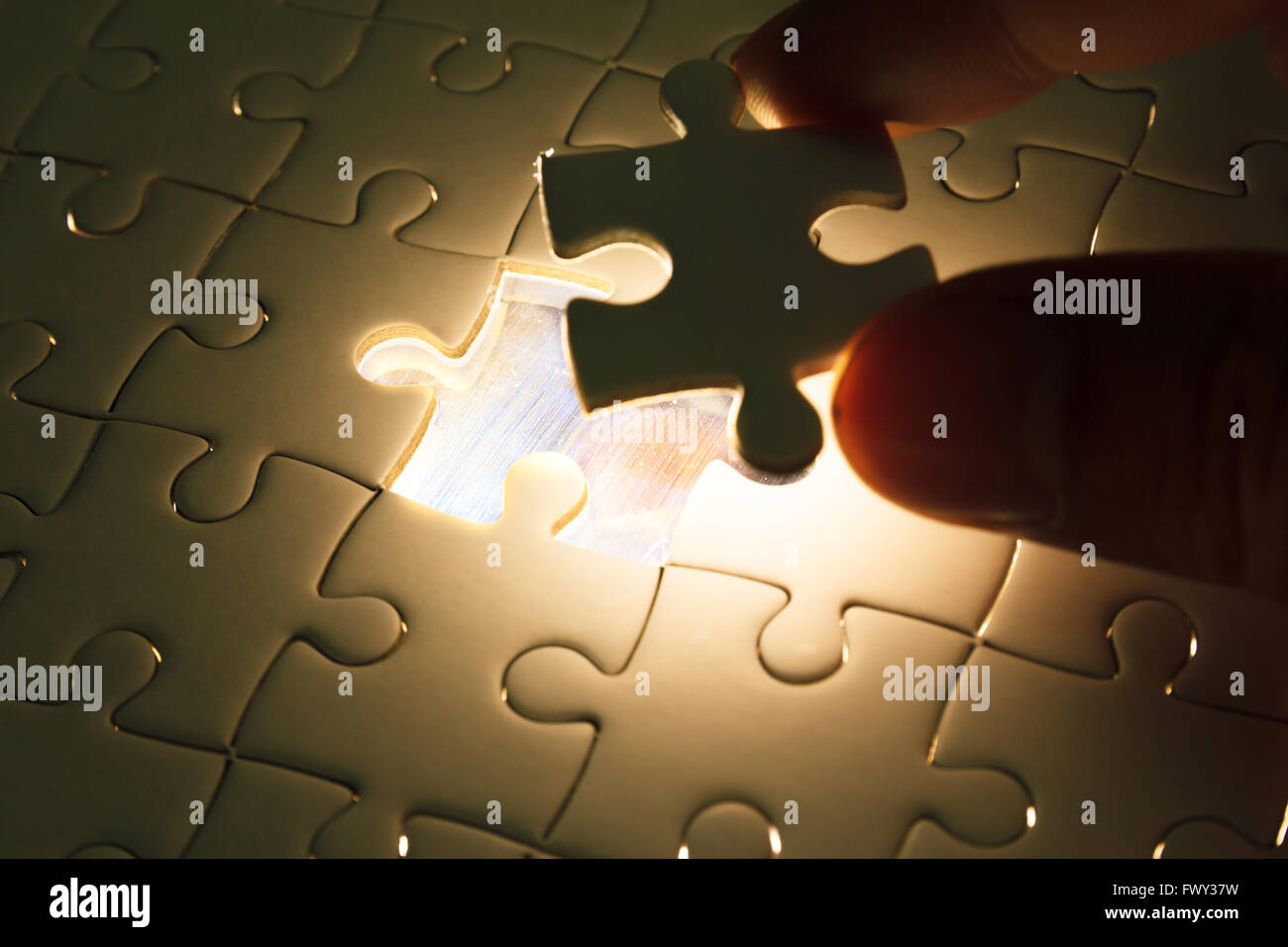Hand insert missing jigsaw puzzle piece with light glow, business ...