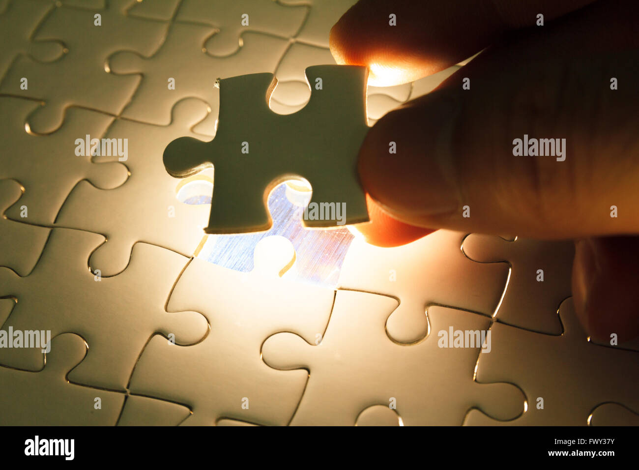 Hand insert missing jigsaw puzzle piece with light glow, business ...