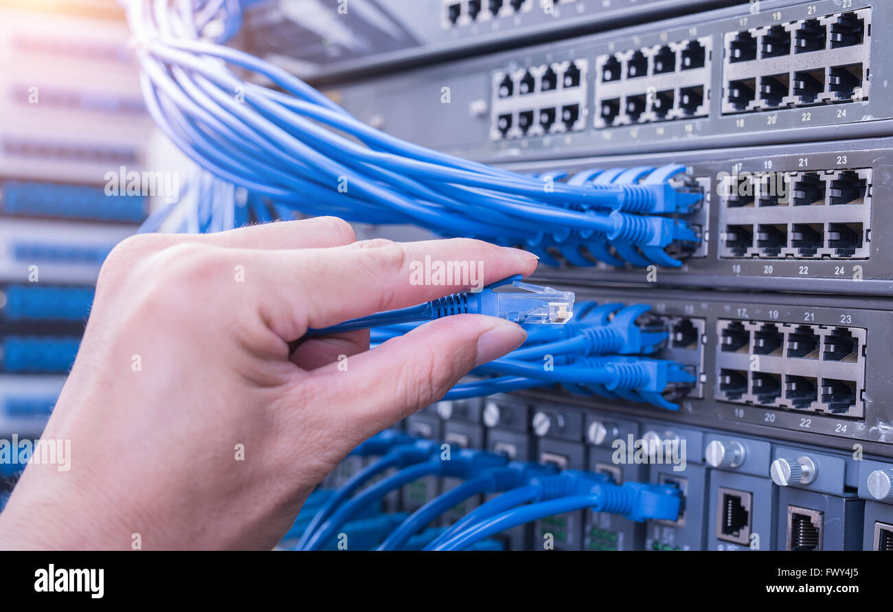 man connecting network cable to switch Stock Photo - Alamy