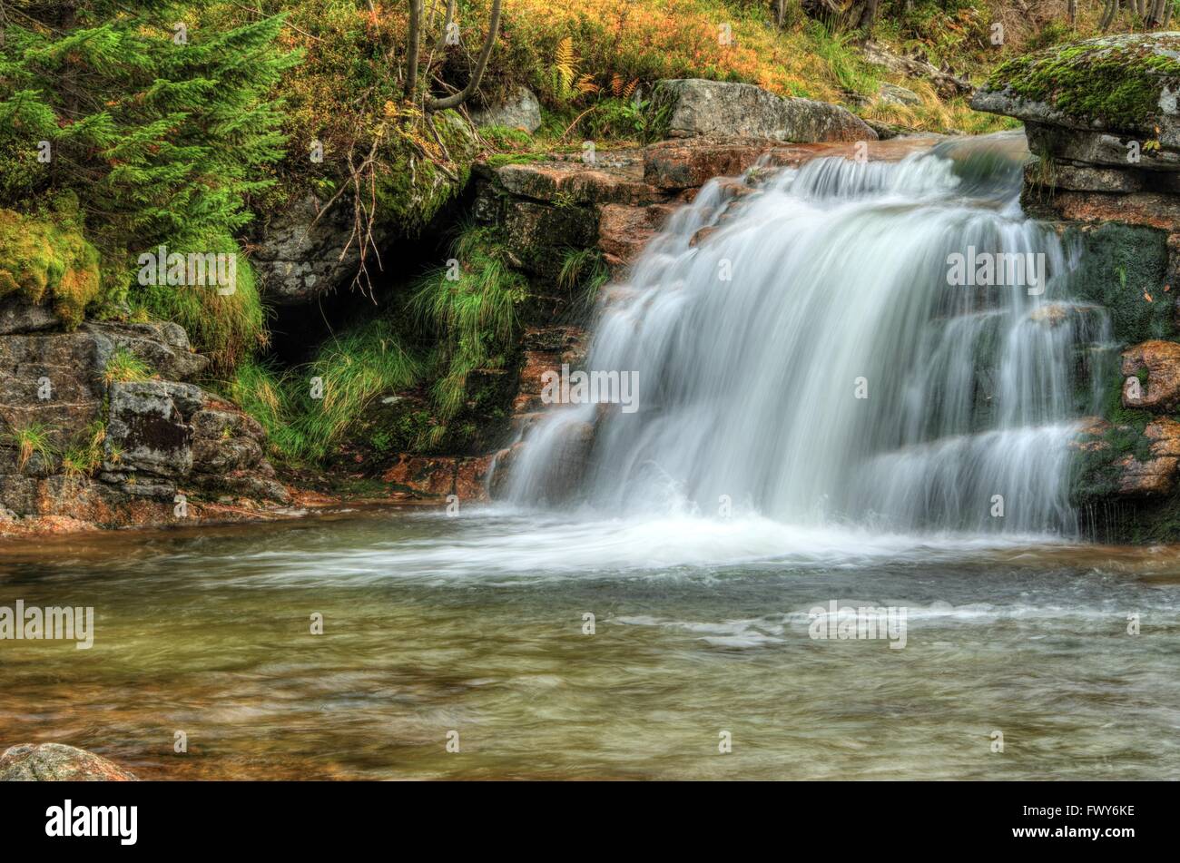 Amazing waterfall in a wooded mountainous landscape Stock Photo - Alamy