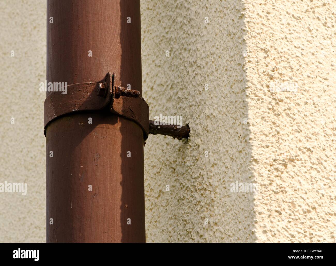 Old rusty brown gutter on the yellow wall Stock Photo - Alamy