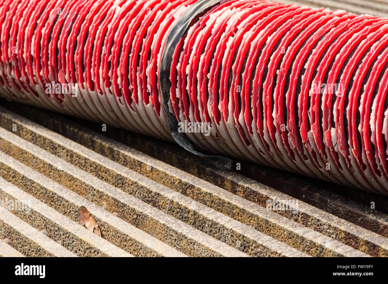 Old red pipe on the steel grate surface Stock Photo - Alamy
