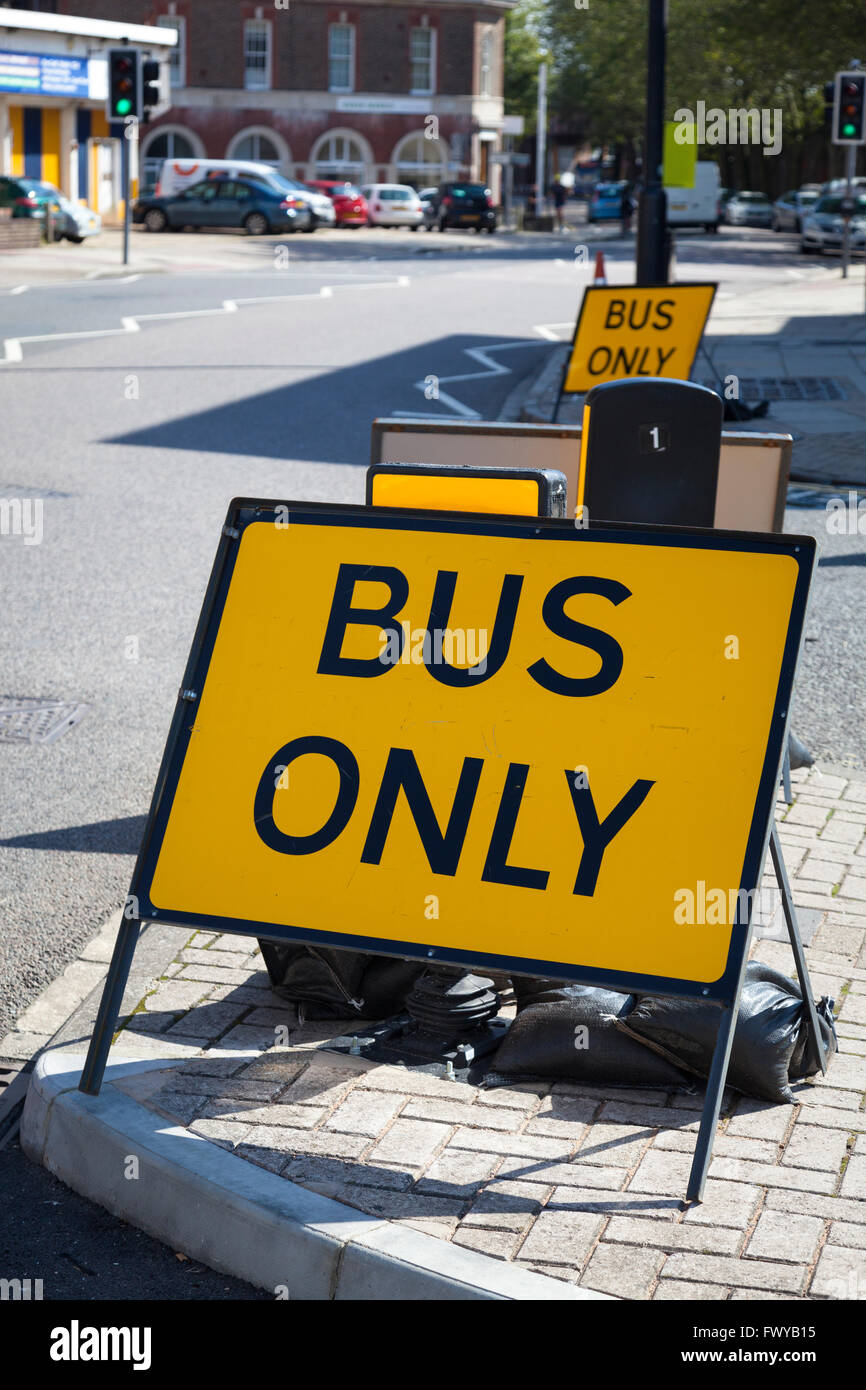 Black on yellow on 'bus only' signs by the side of the road Stock Photo ...