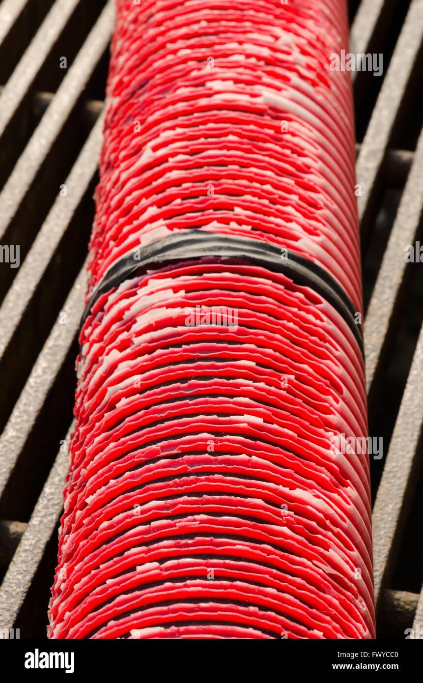 Old red pipe with black tape connection on grate Stock Photo - Alamy