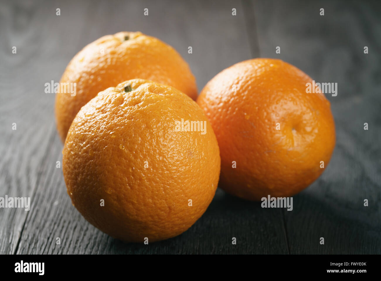 three fresh ripe oranges on oak wooden table Stock Photo - Alamy