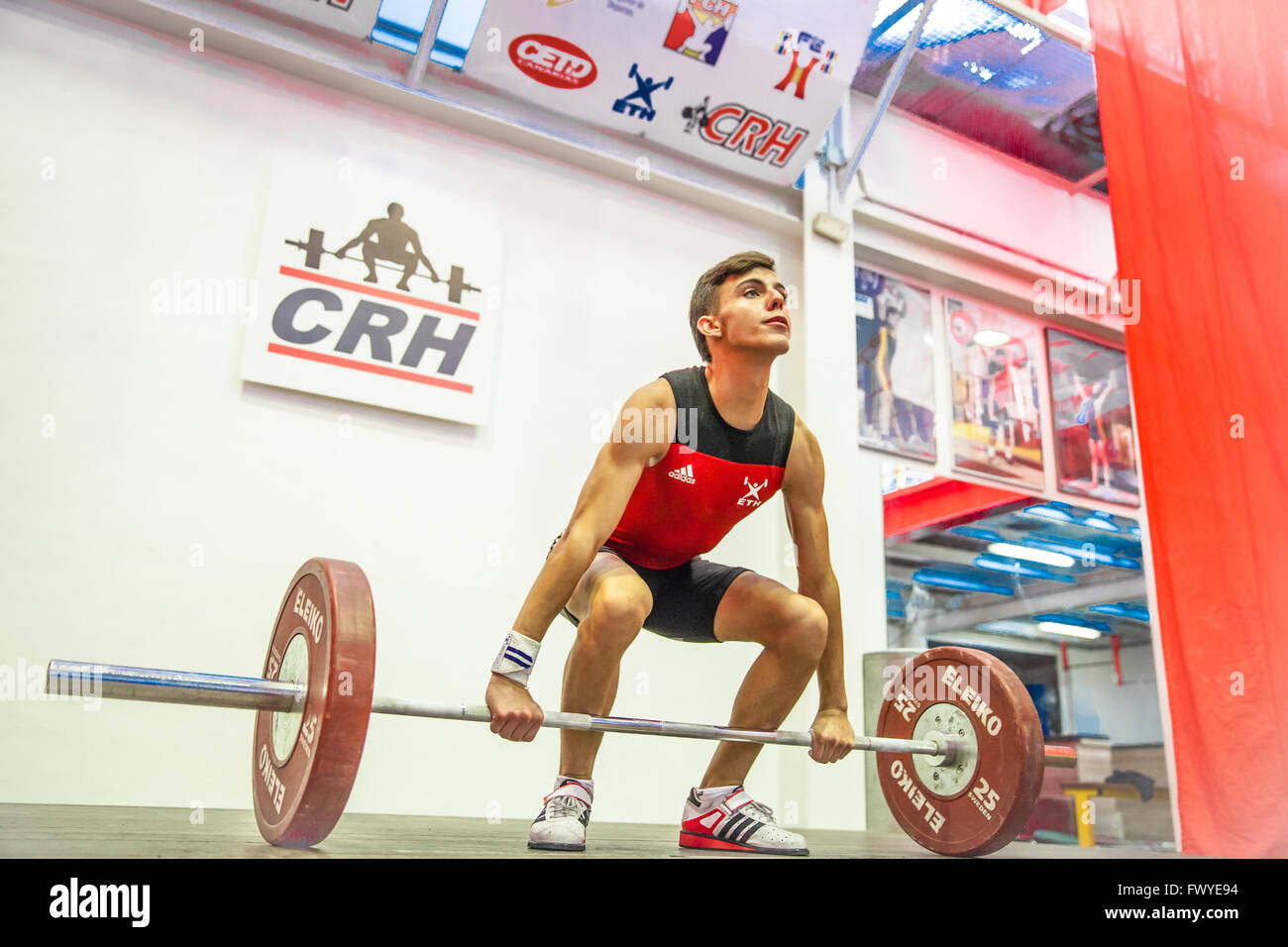Muscled boy lifting weight in a public exhibition Stock Photo - Alamy
