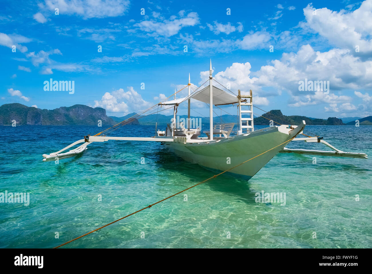 Traditional wooden boat in clear sea water, El Nido, Palawan ...