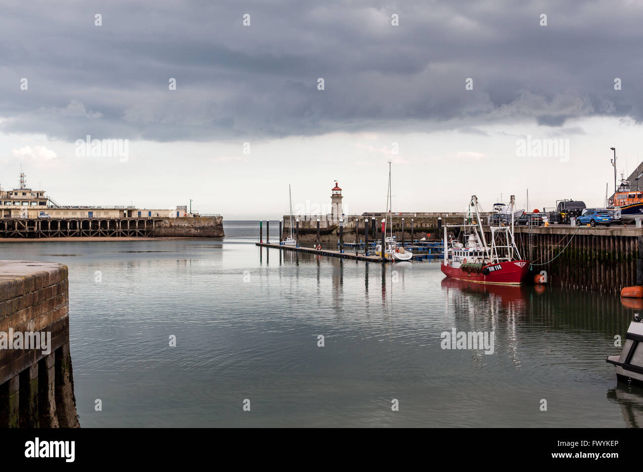 Ramsgate Harbour with stormy clouds and red boat Stock Photo - Alamy