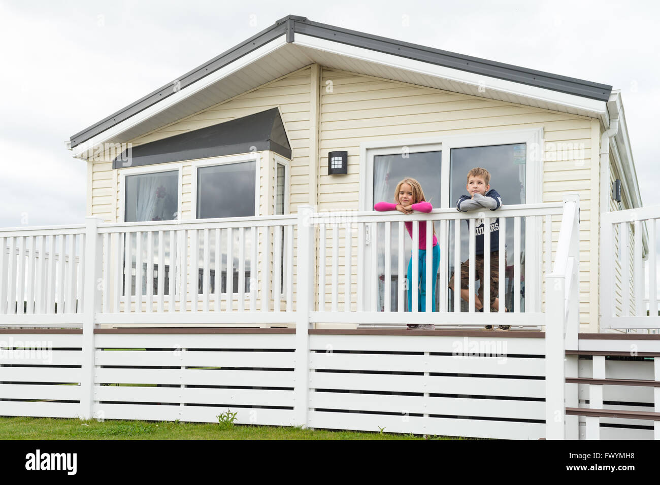 brother and sister outside white static caravan admiring the view ...