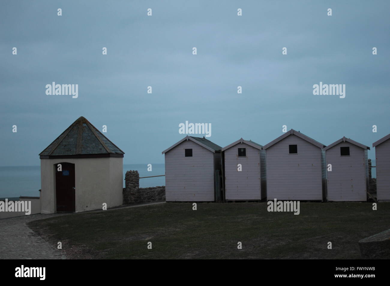 wooden seaside huts in line with turret Stock Photo - Alamy