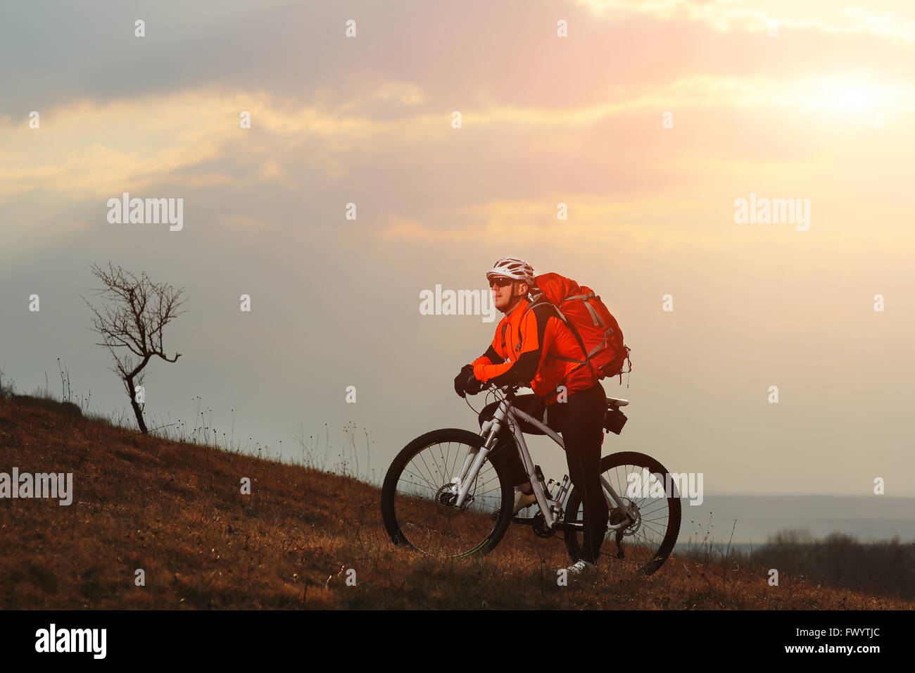 Man cyclist with backpack riding the bicycle Stock Photo - Alamy