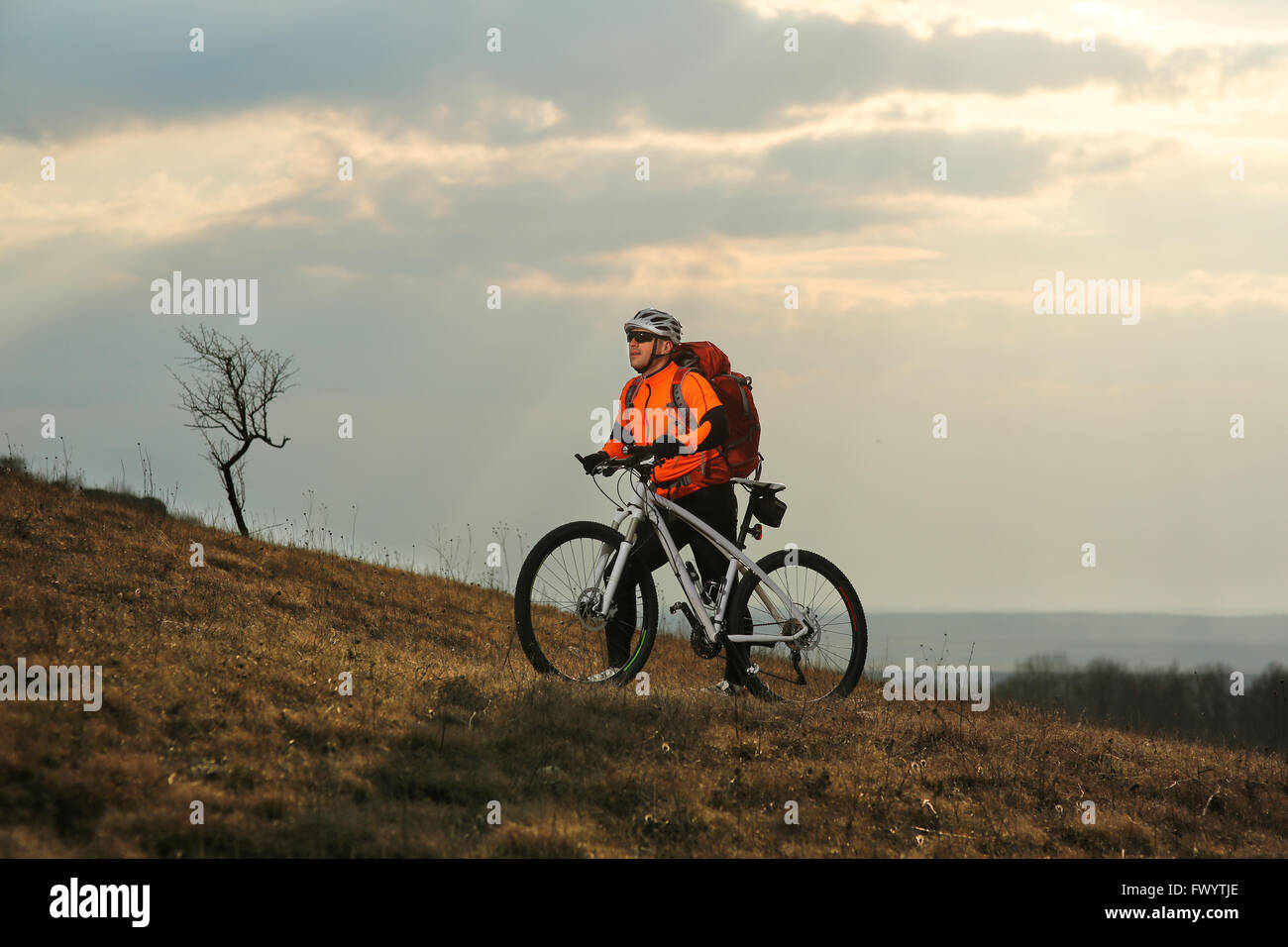 Man cyclist with backpack riding the bicycle Stock Photo - Alamy