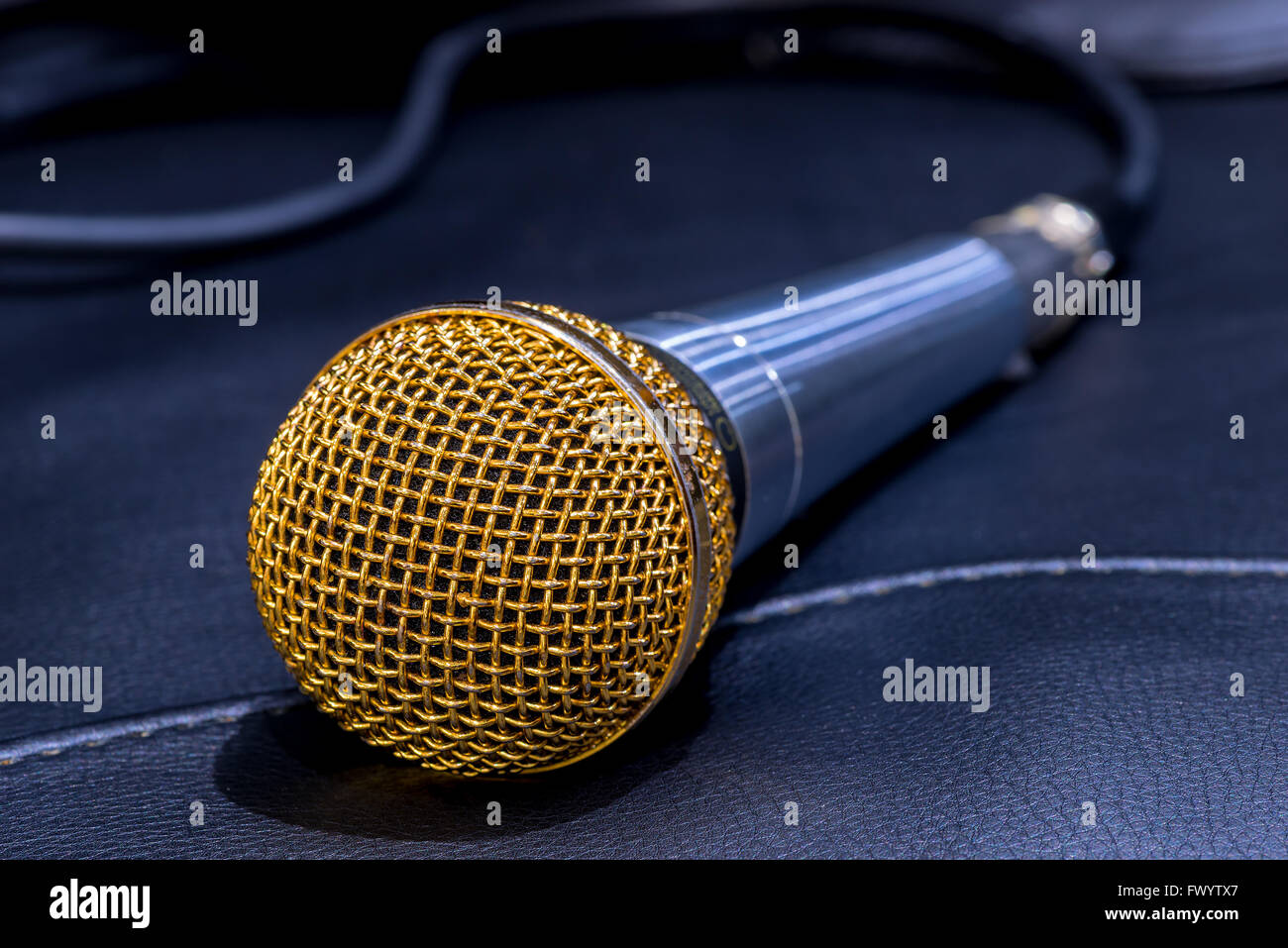 microphone lying on a black leather couch photo is closeup Stock Photo ...