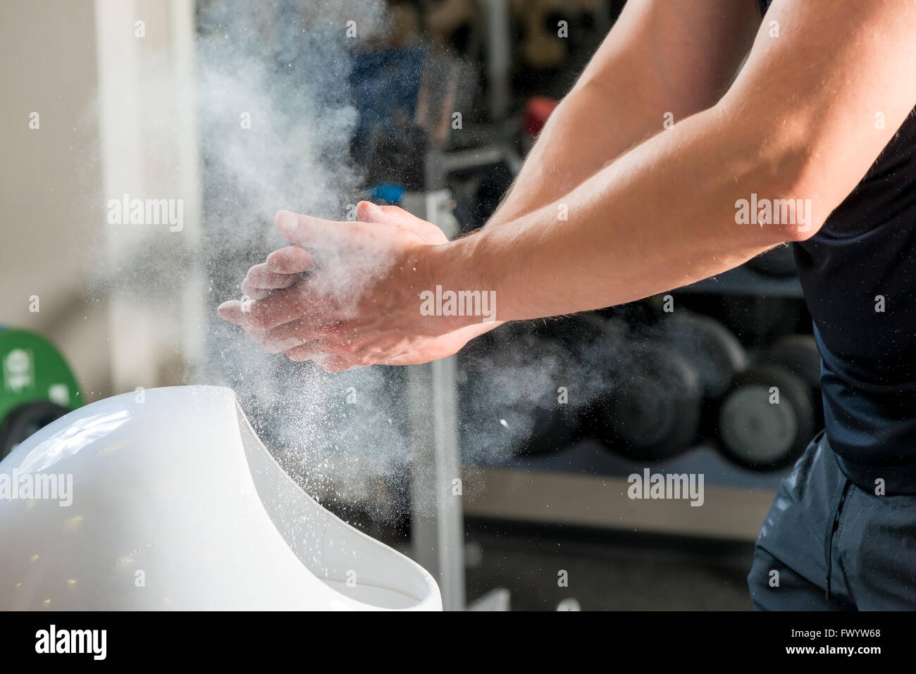 male weightlifter processes hands talcum powder against sliding Stock ...