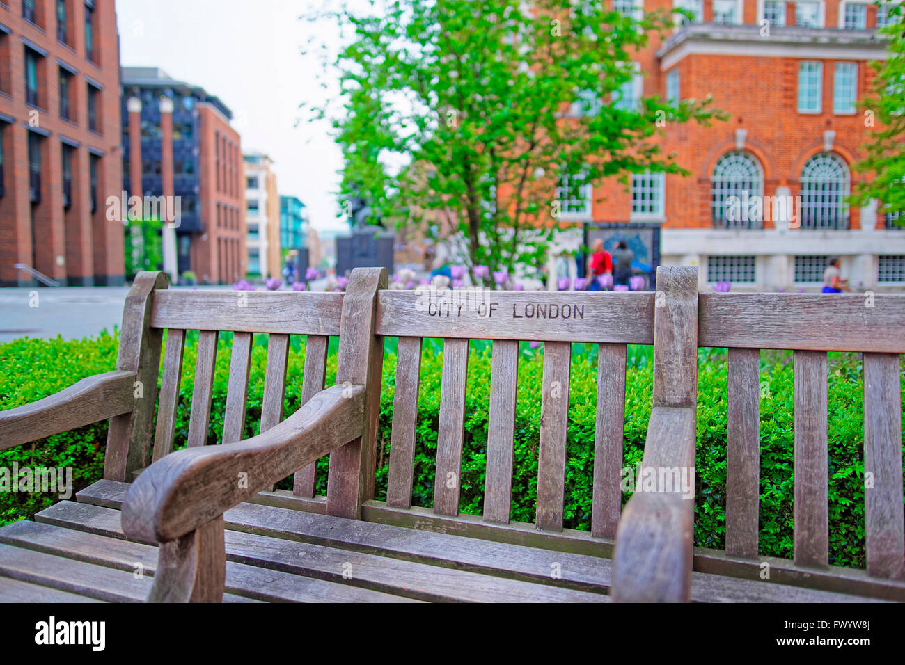 Wooden bench in the City of London in the downtown of London in England ...