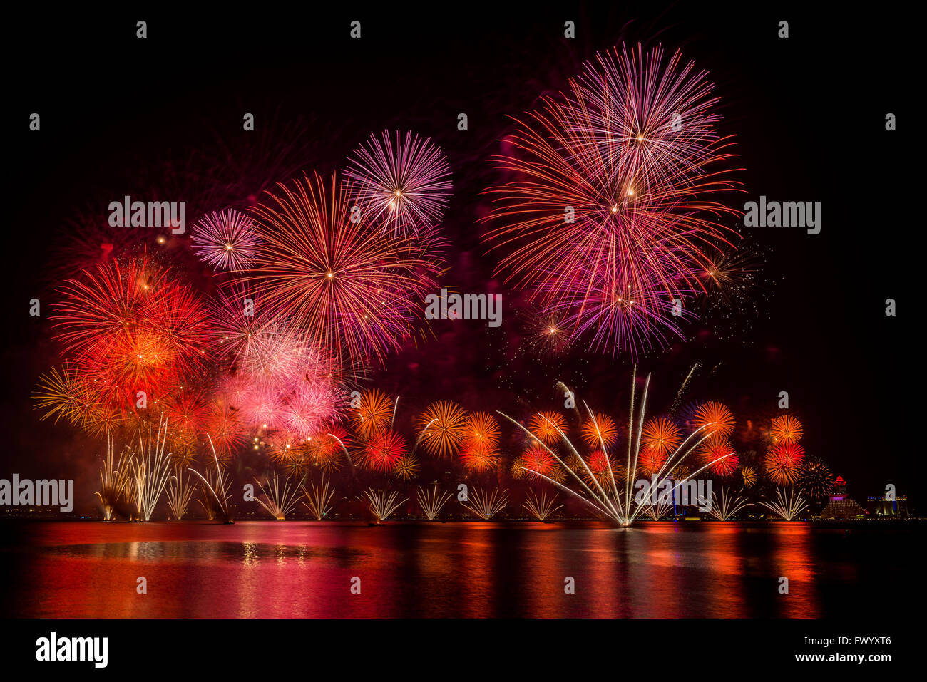 Firework display at night over water. National day celebrations Doha ...