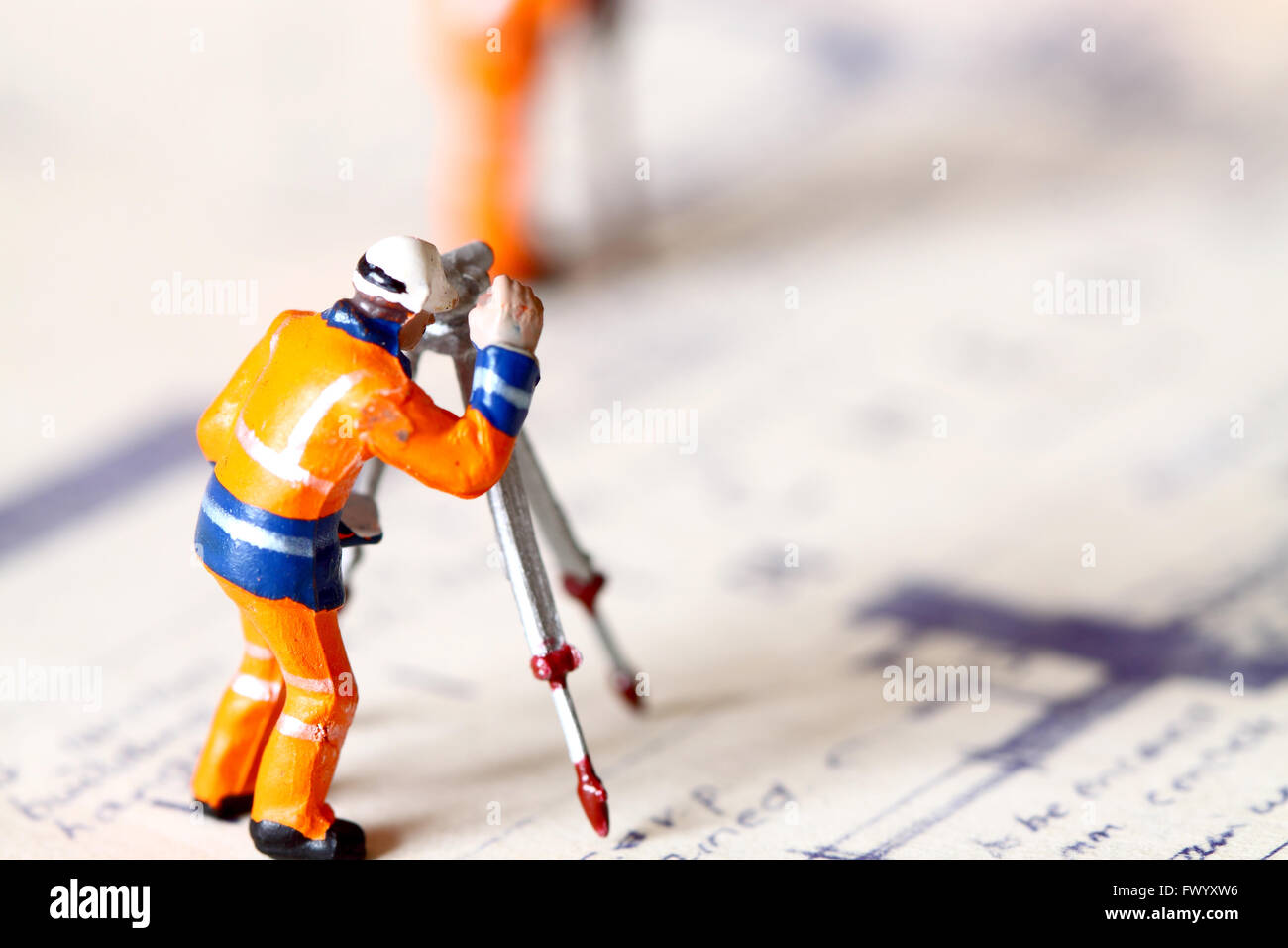 Miniature construction workers building plans Stock Photo - Alamy