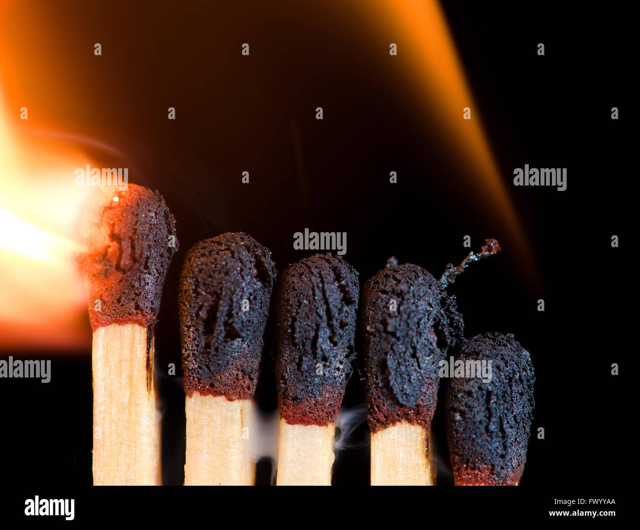 Close-up of five burning matches on black background Stock Photo - Alamy