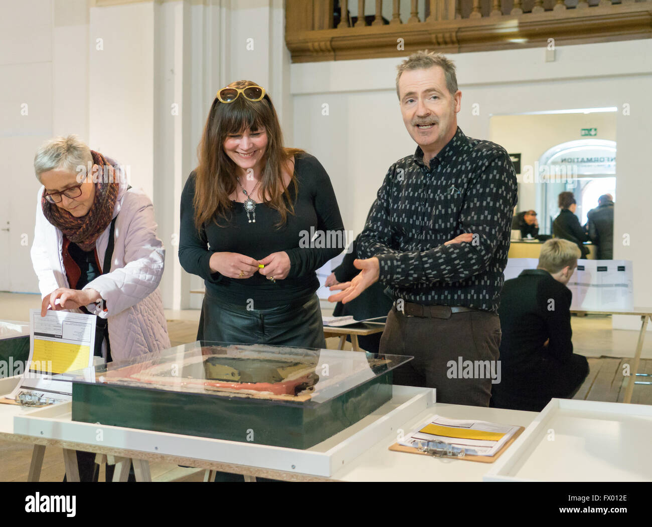 Man and woman observing and discussing object on a table at an art ...