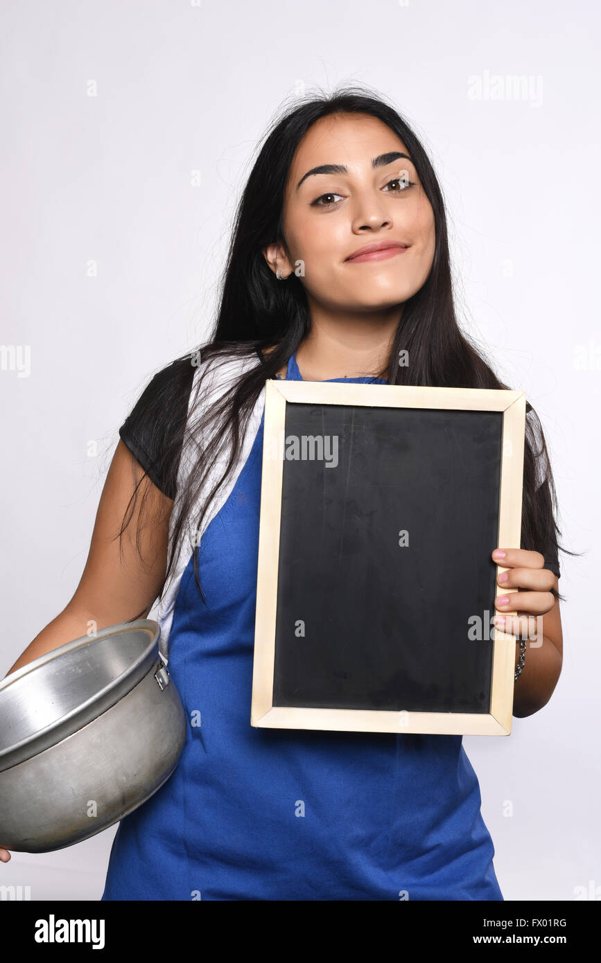 Young woman with cooking utensils and holding chalkboard. Isolated ...
