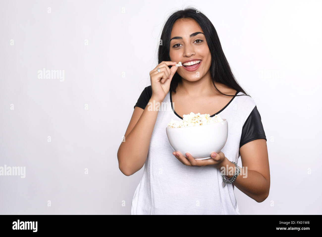 Young beautiful woman eating popcorn. Isolated white background Stock ...