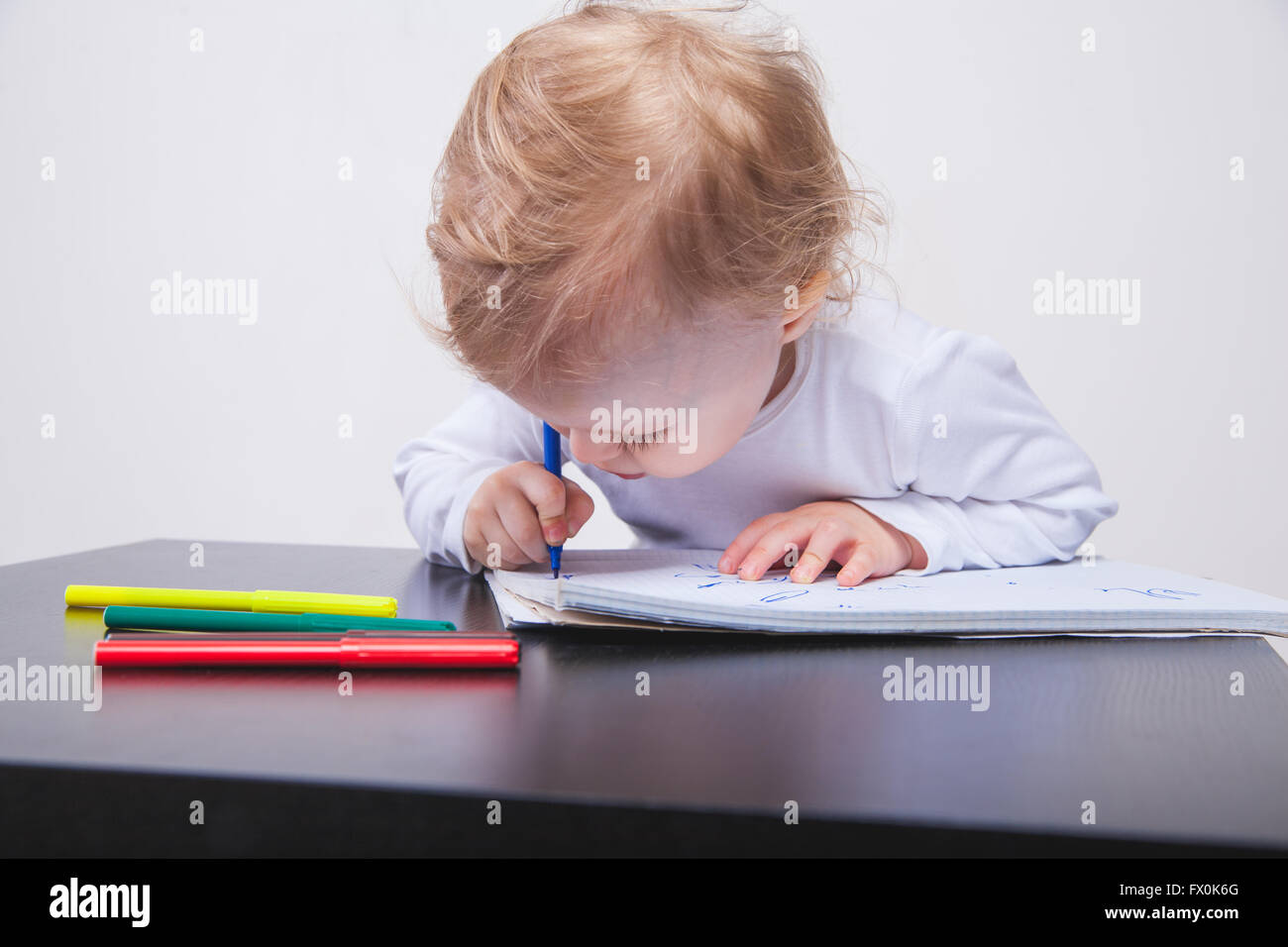 Baby girl drawing with colorful felt-tip pens on white background Stock ...