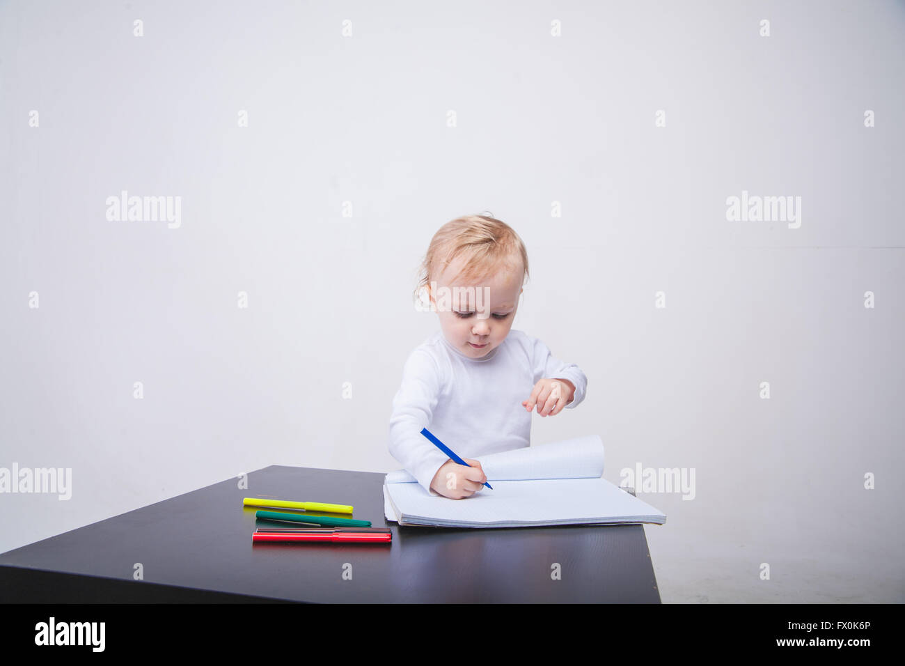 Baby girl drawing with colorful felt-tip pens on white background Stock ...