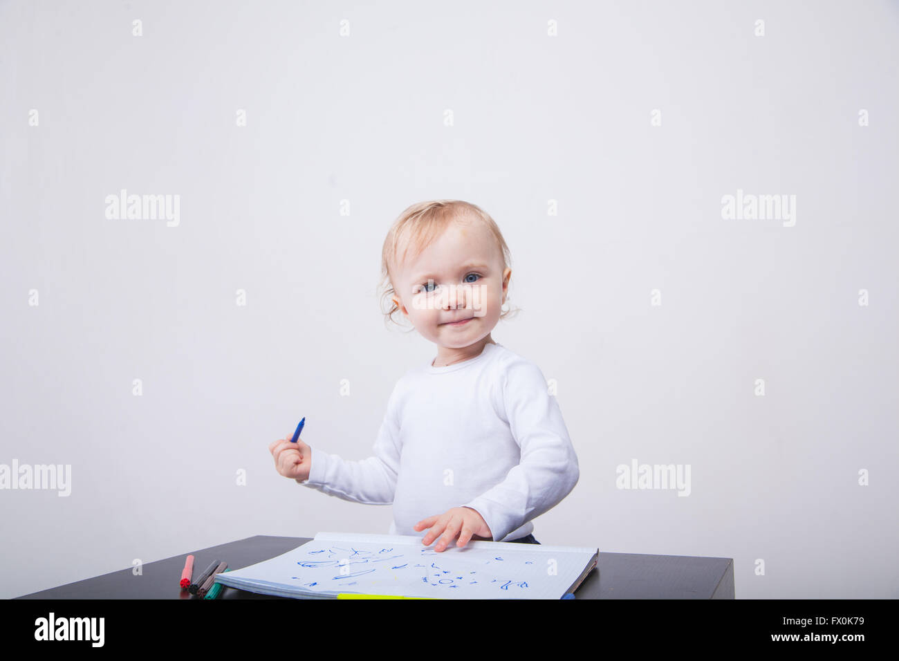 Baby girl drawing with colorful felt-tip pens on white background Stock ...