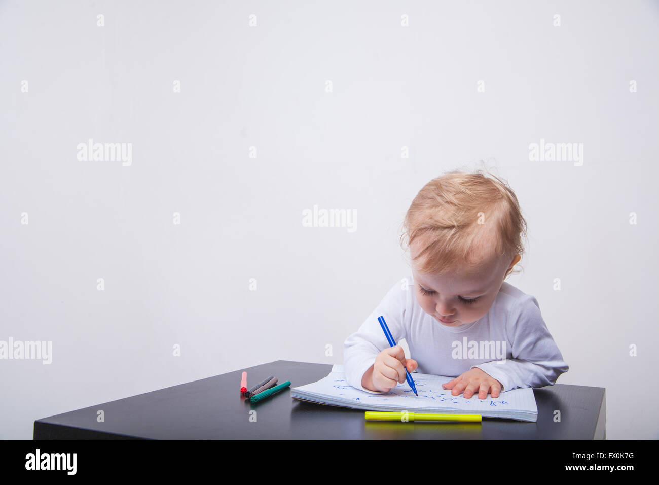 Baby girl drawing with colorful felt-tip pens on white background Stock ...