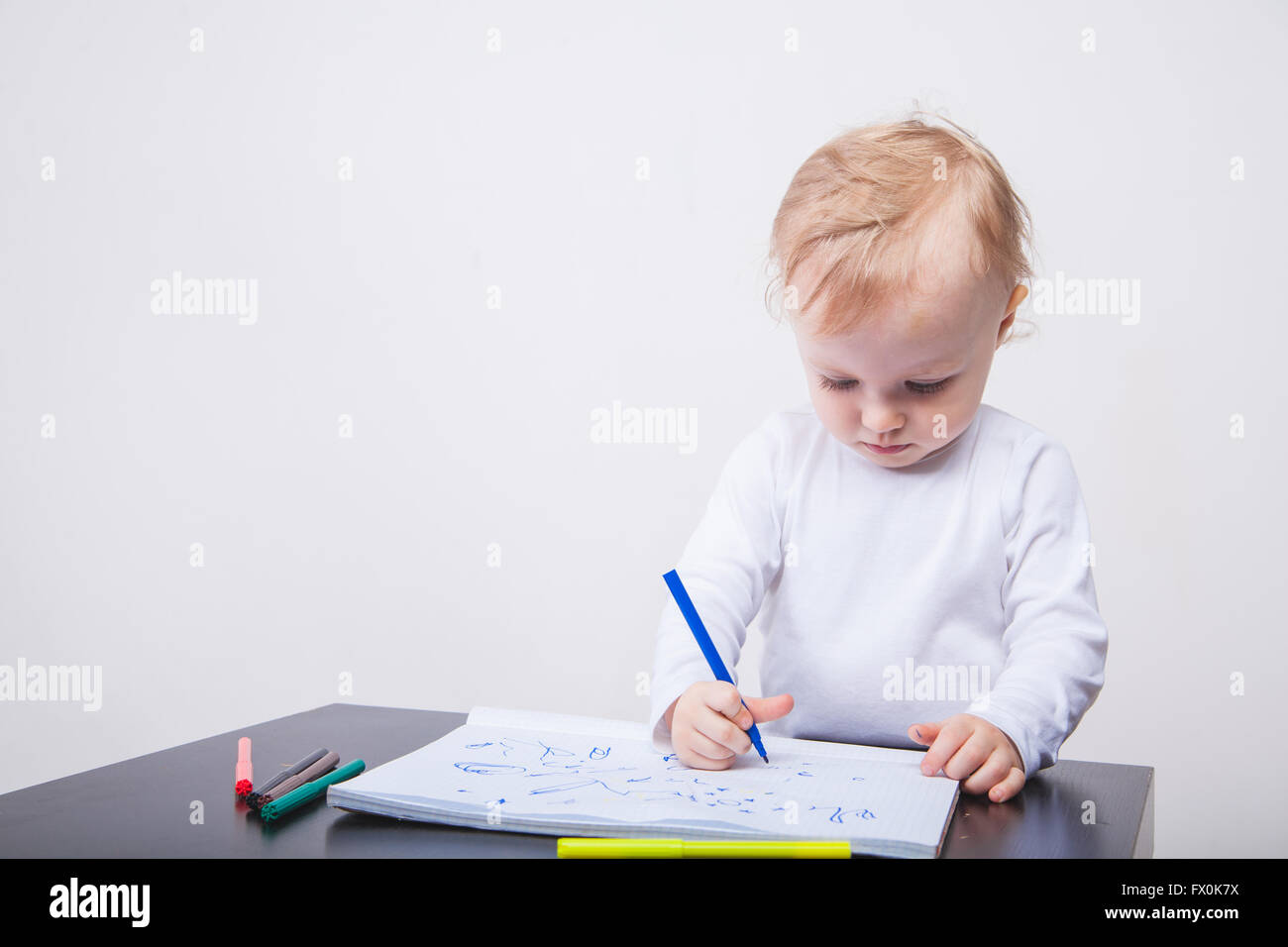 Baby girl drawing with colorful felt-tip pens on white background Stock ...
